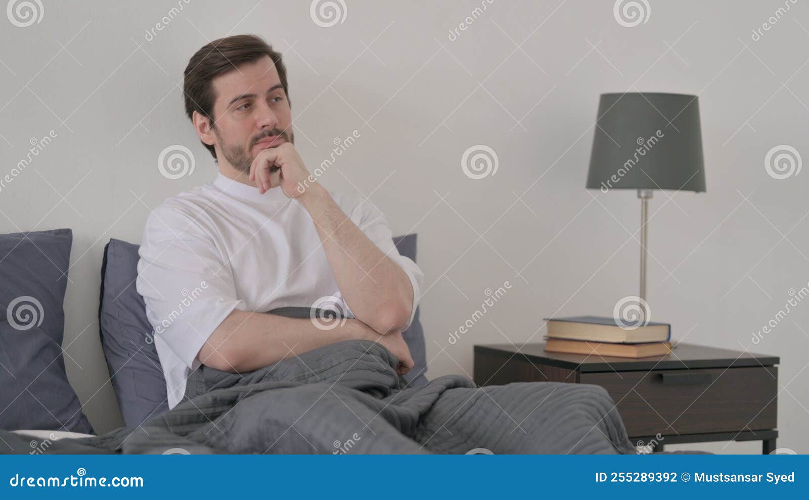 Young Man Thinking while Sitting in Bed Stock Photo - Image of ...
