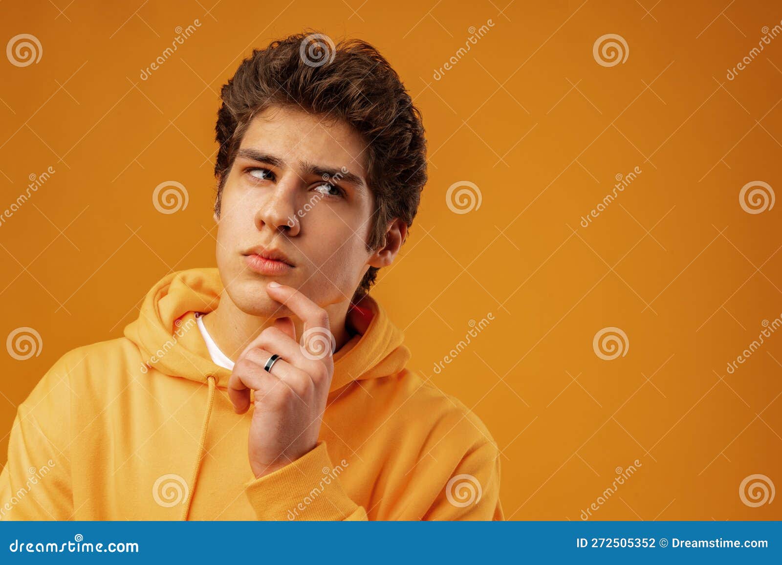 Young Man Thinking about Things on Yellow Background Stock Photo ...