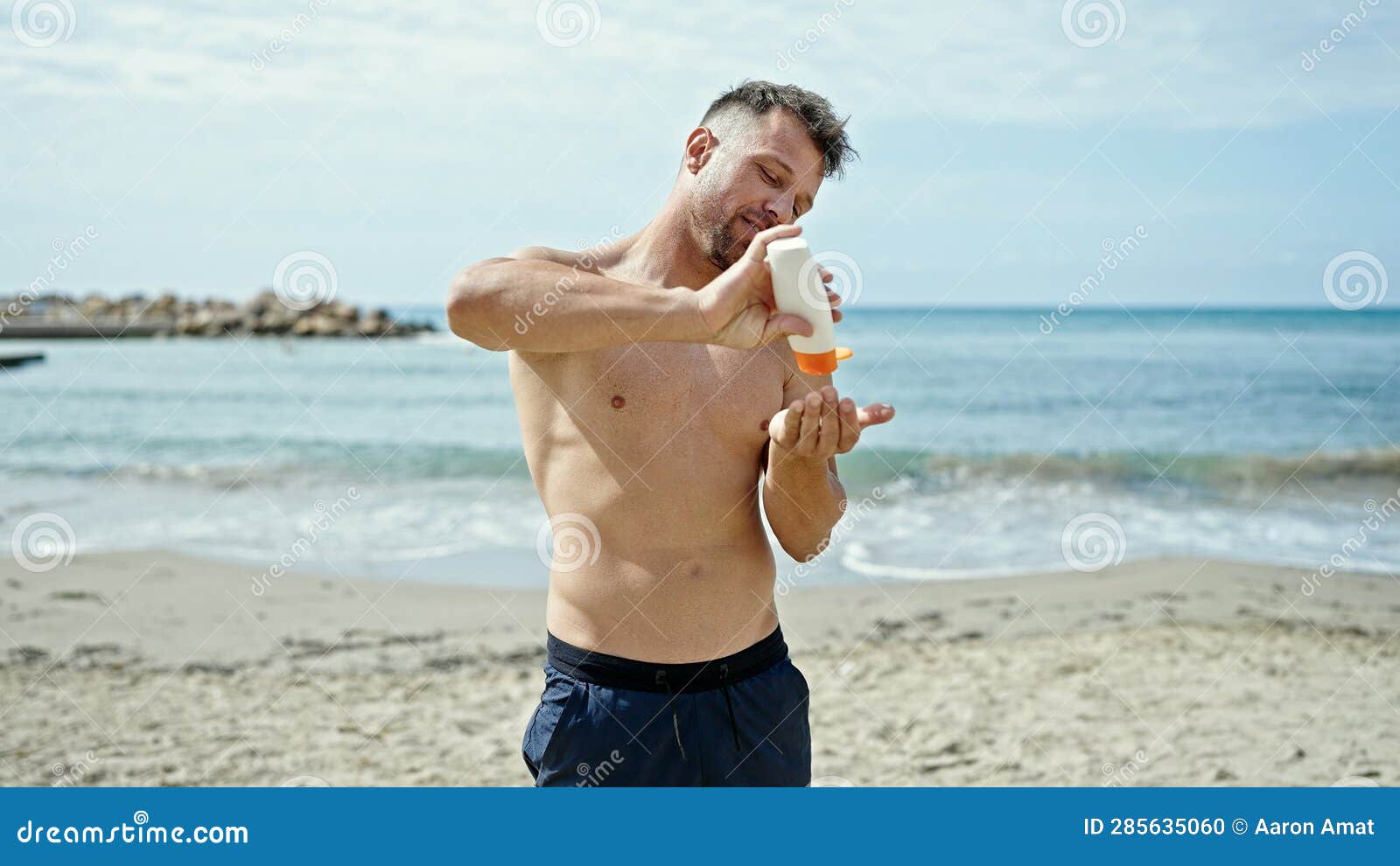 Young Man Tourist Applying Sunscreen at the Beach Stock Photo - Image ...