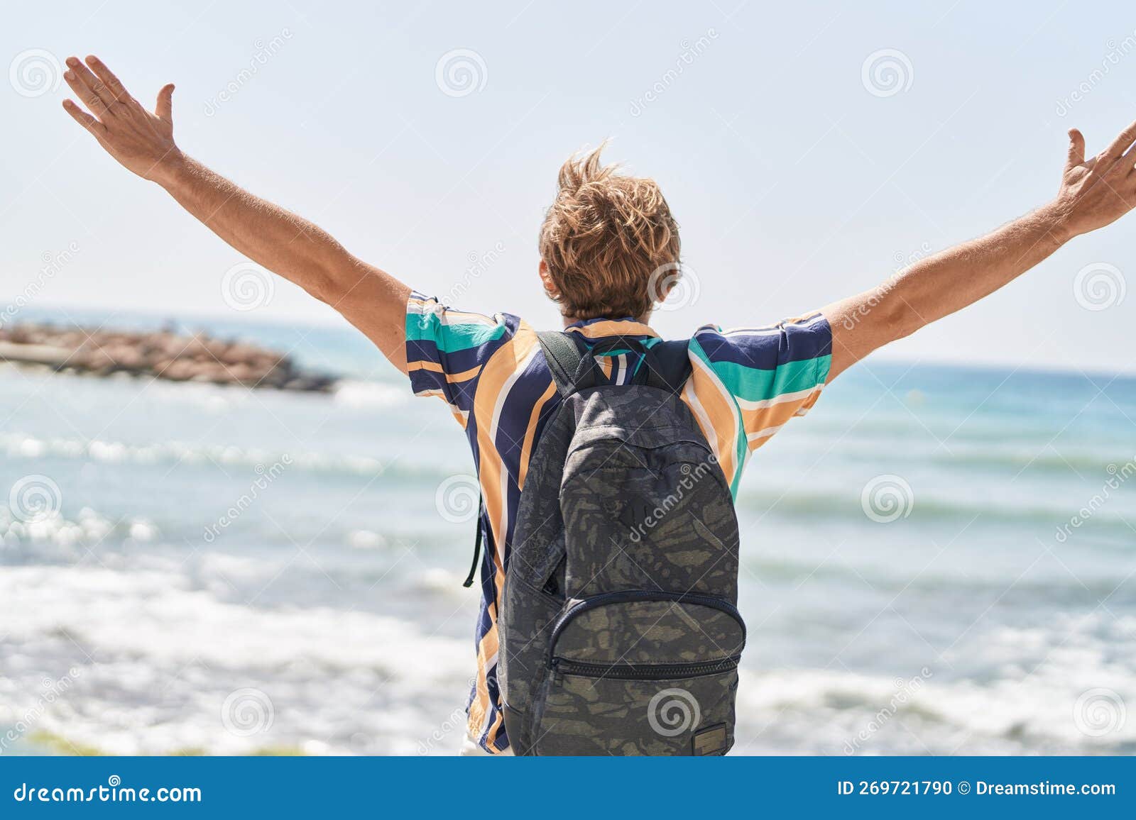 Young Man Tourist Wearing Backpack with Arms Open at Seaside Stock ...