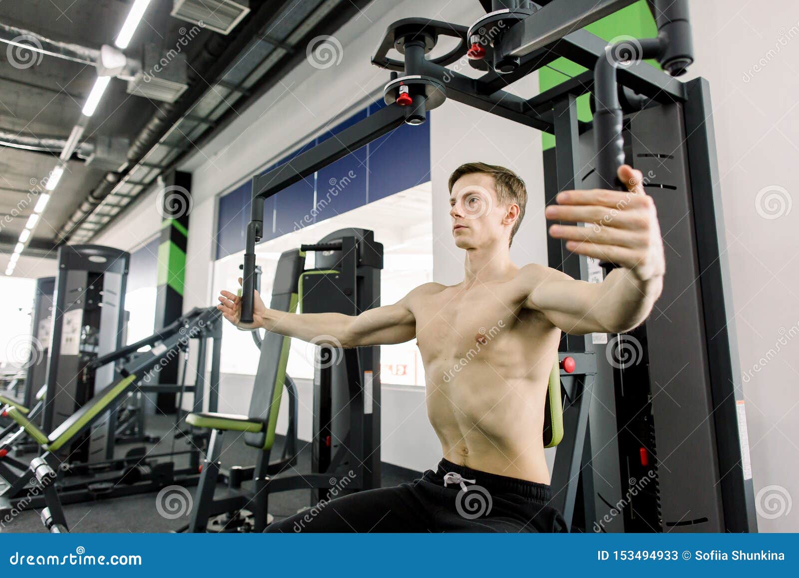 Young Man Training in the Gym. Ripped Bodybuilder Working Out in Gym ...