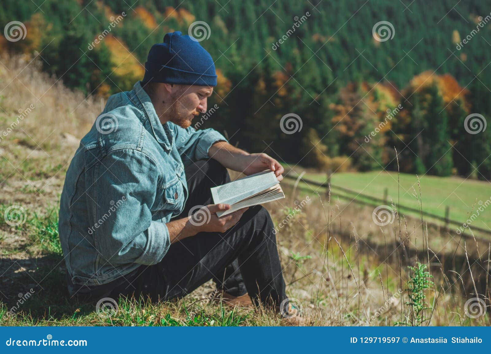 Young Man Traveler Reading Book, Outdoor Mountains on Background Summer ... Young Man Traveler Reading Book, Outdoor Mountains on Background Summer ...