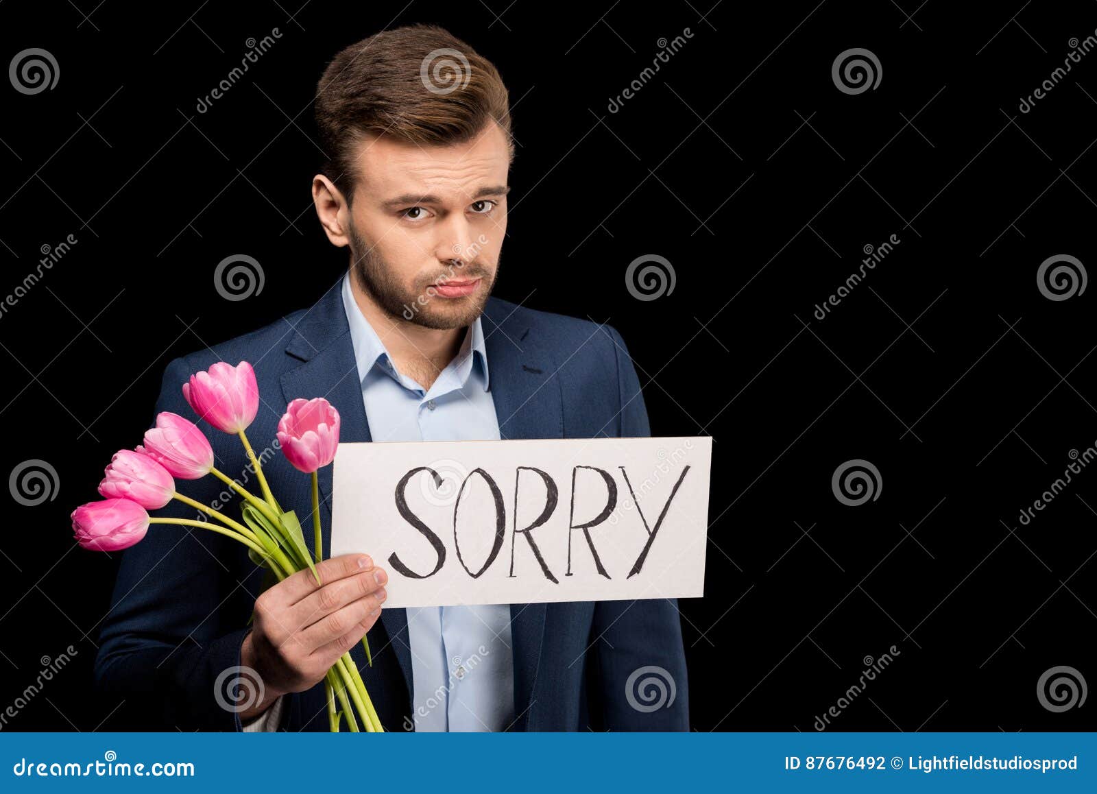 Young Man with Tulips and Sorry Sign Looking at Camera Stock Photo ...