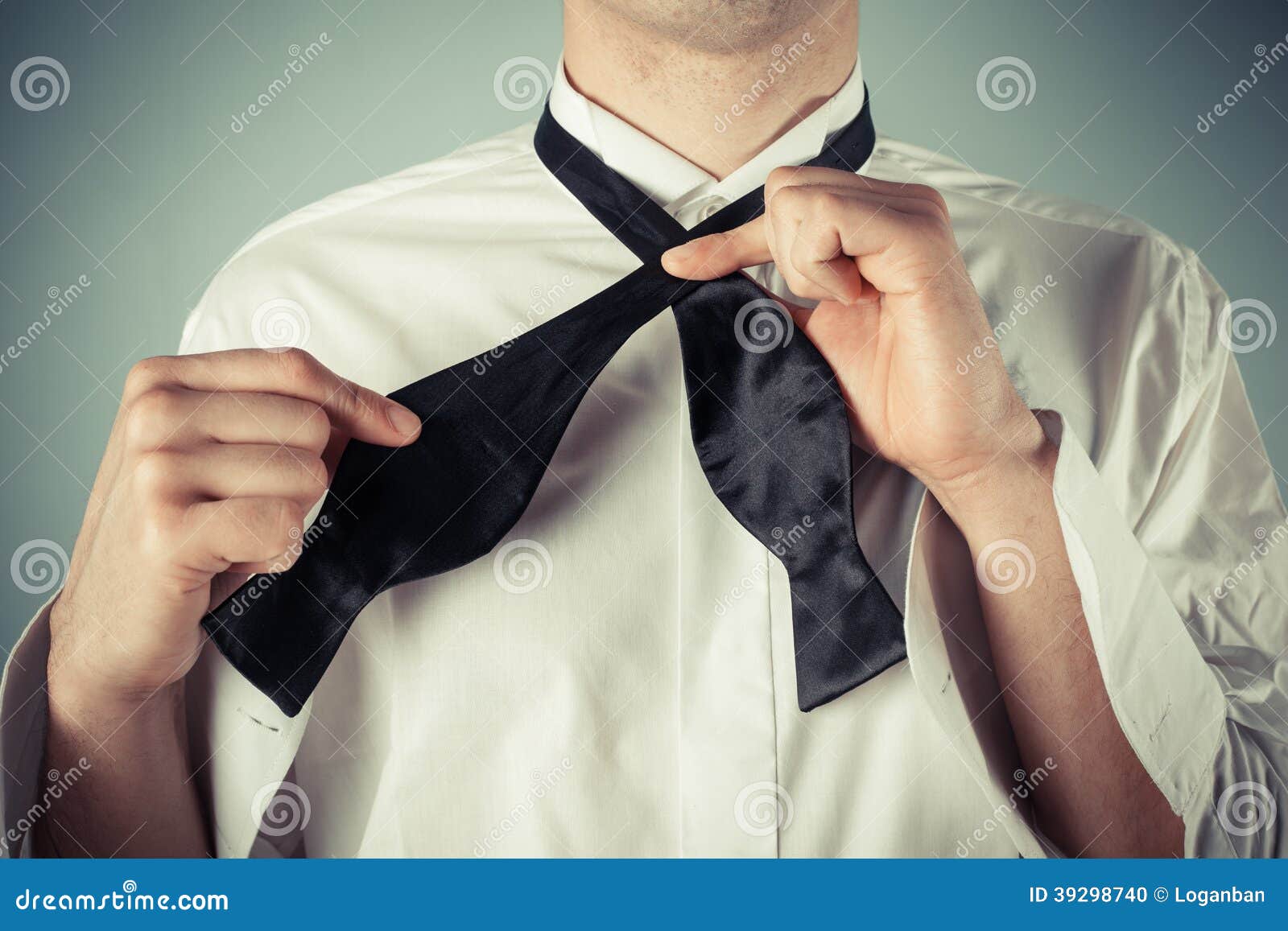 Young man tying a bow tie stock photo. Image of male - 39298740