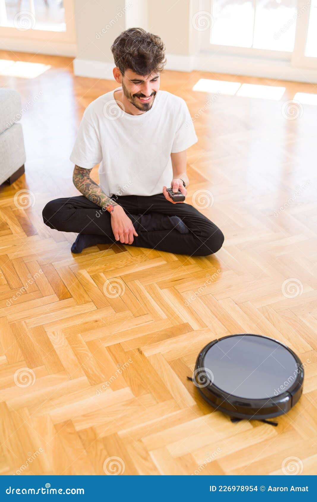 Young Man Using Automatic Vacuum Cleaner To Clean the Floor, Controling ...
