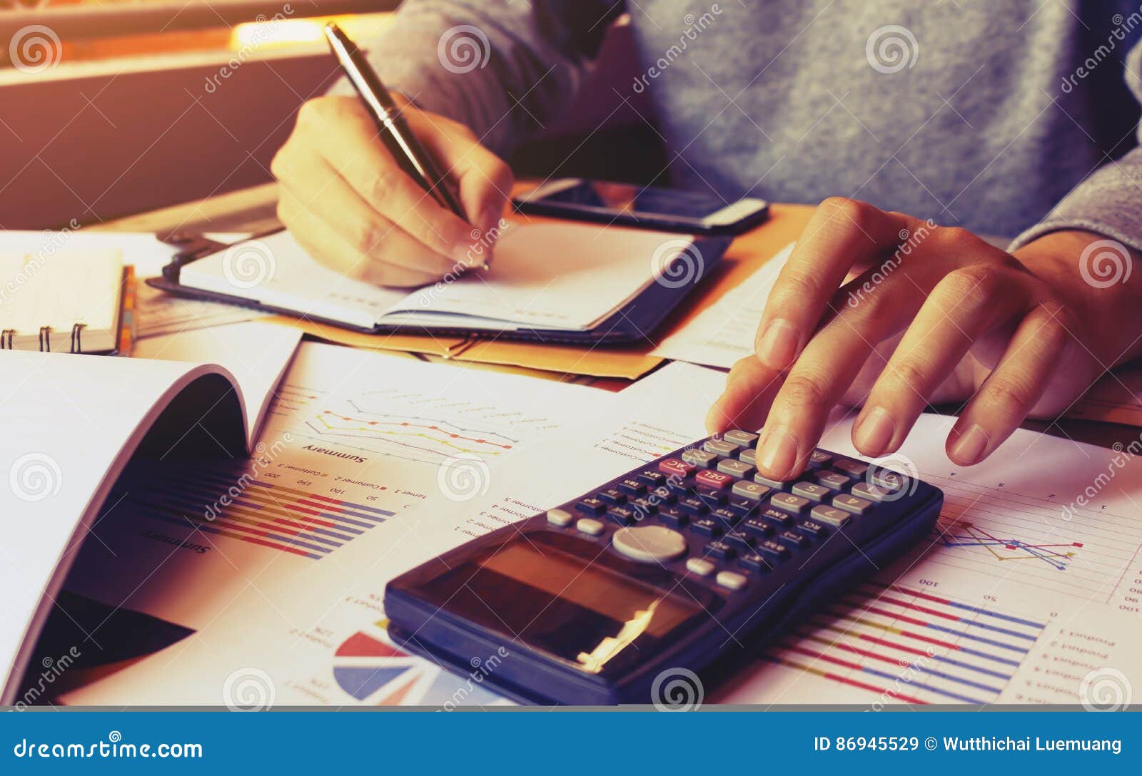 Young Man Using Calculator and Writing Note and Calculate Finance at ...