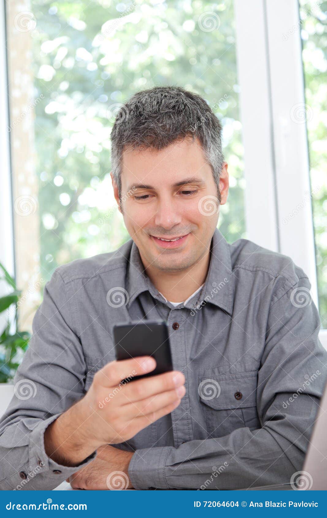 Young man using cell phone stock photo. Image of shirt - 72064604