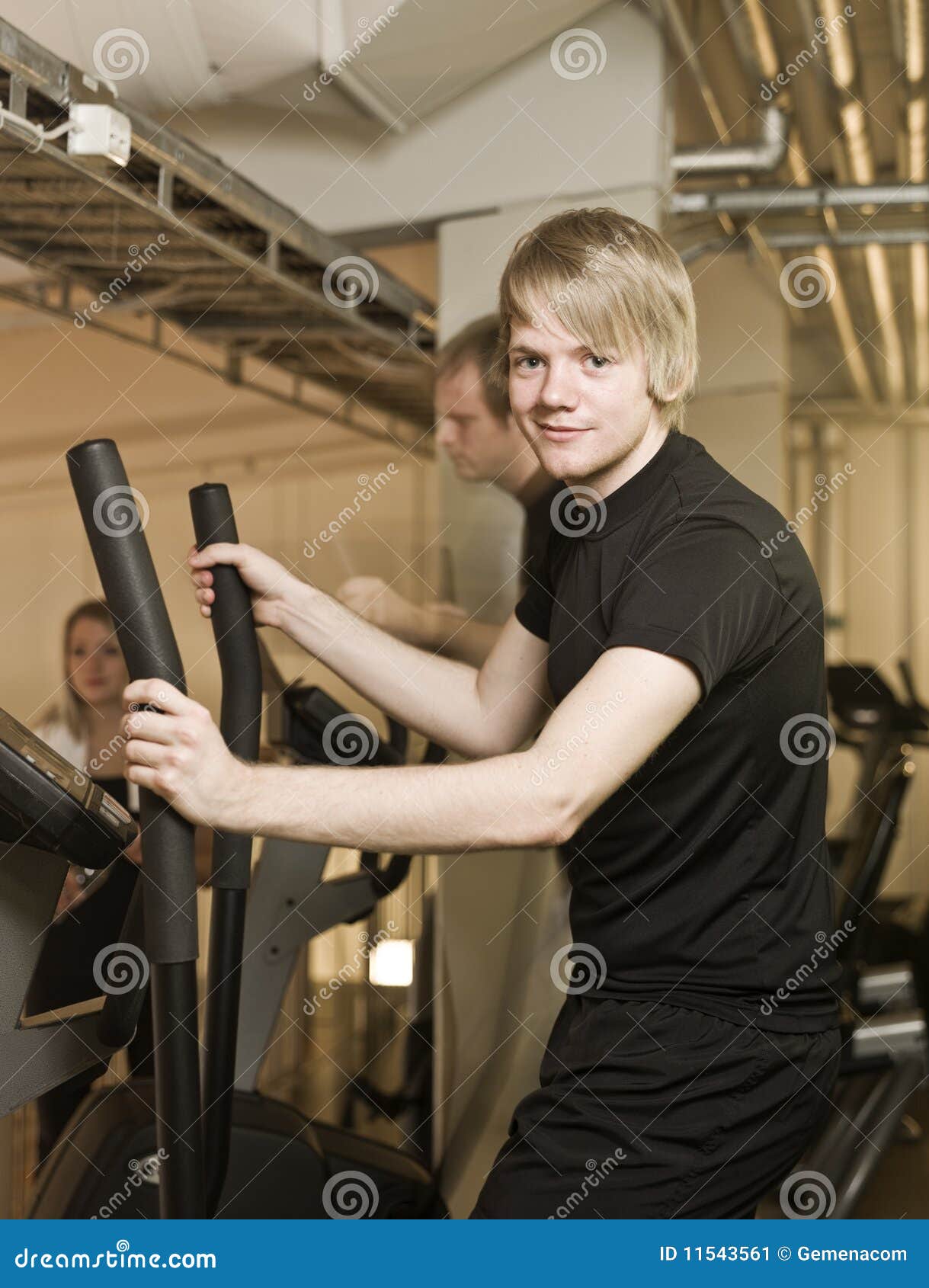 Young Man Using an Exercise Machine Stock Image - Image of flexing ...