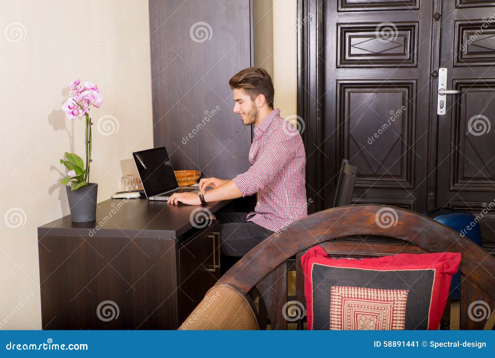 Young Man Using a Laptop Computer in a Asian Styled Hotel Room Stock ...