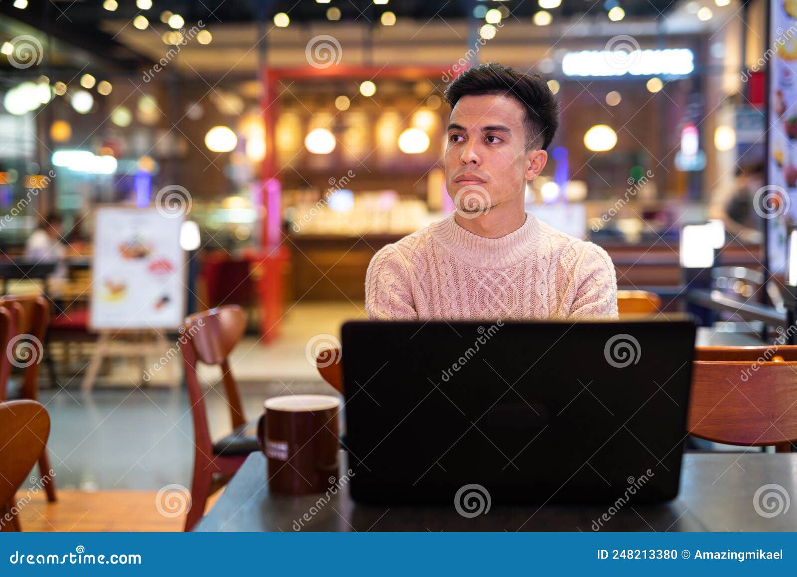 Young Man Using Laptop Computer at Coffee Shop Stock Photo - Image of ...