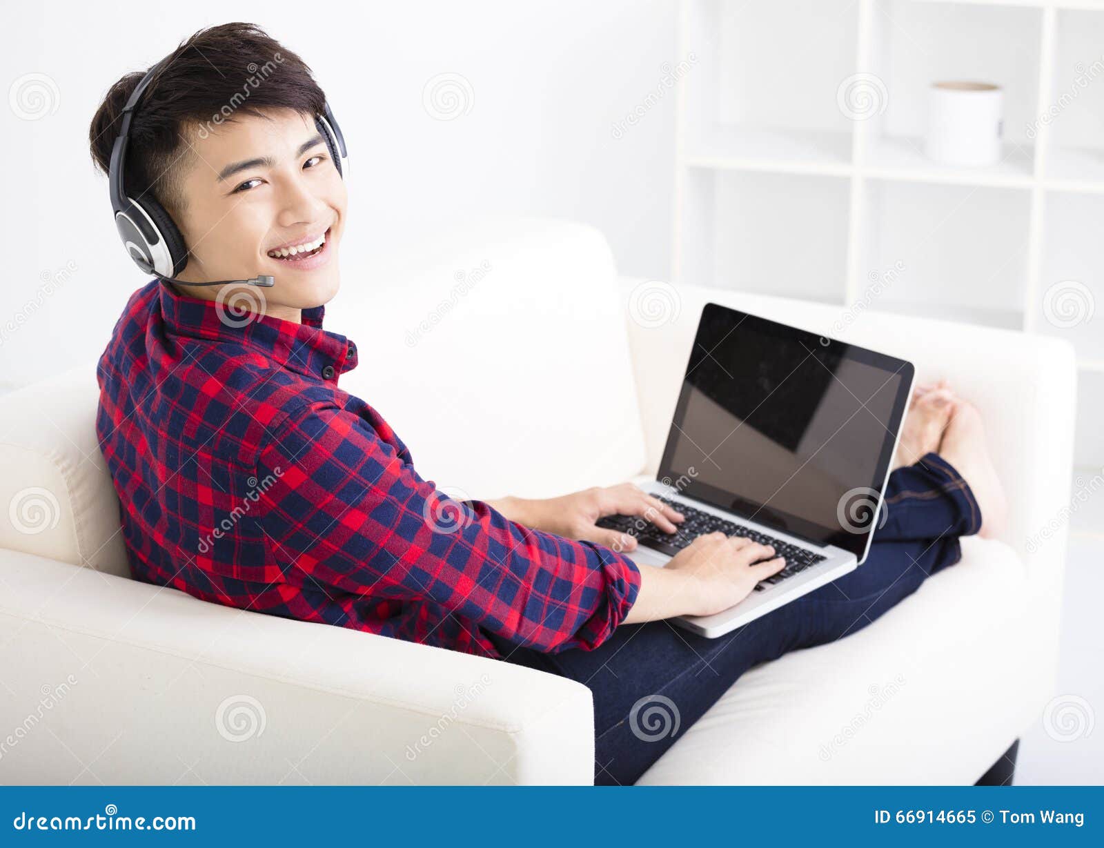 Young Man Using Laptop Computer with Headset Stock Image - Image of ...
