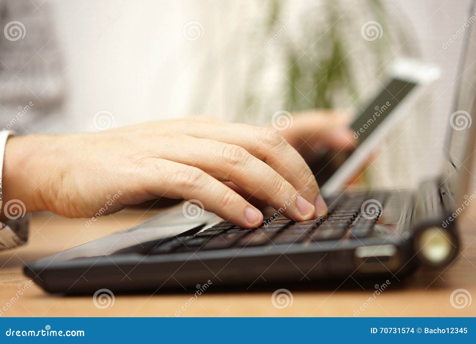 Young Man is Using Laptop Computer and Mobile Phone at the Same Stock ...