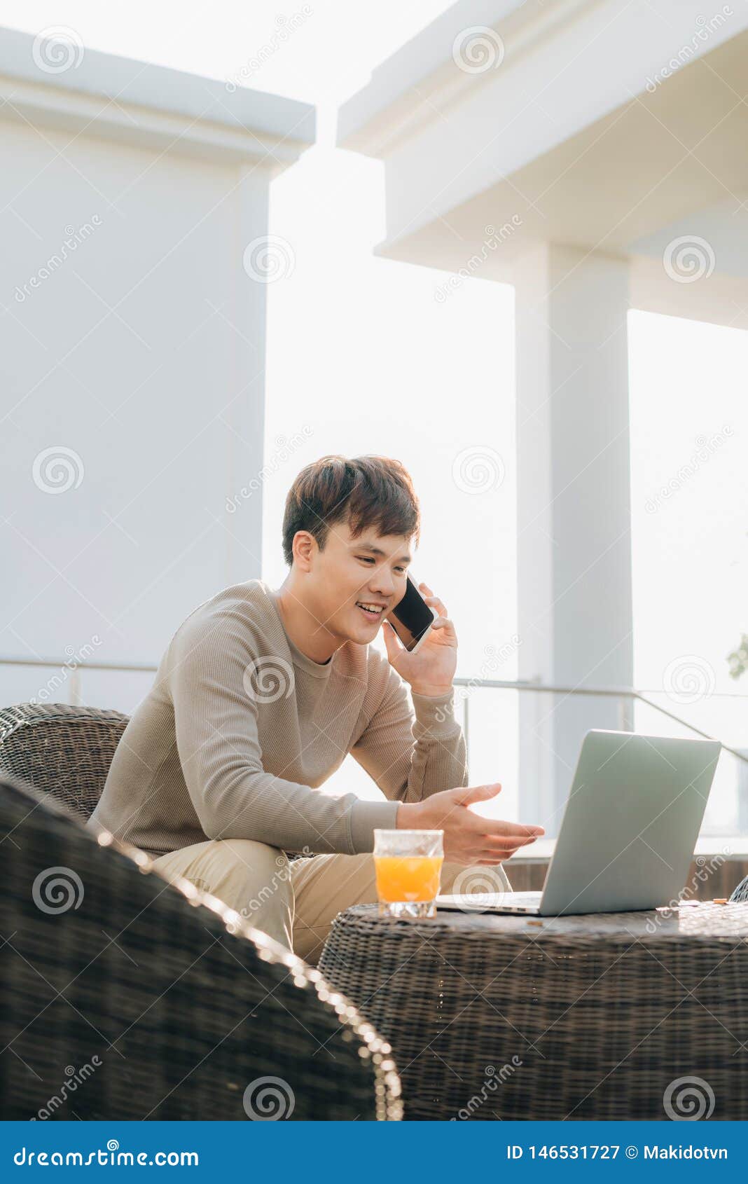 A Young Man Using Laptop Computer while Sitting on a Sofa Outside Stock ...