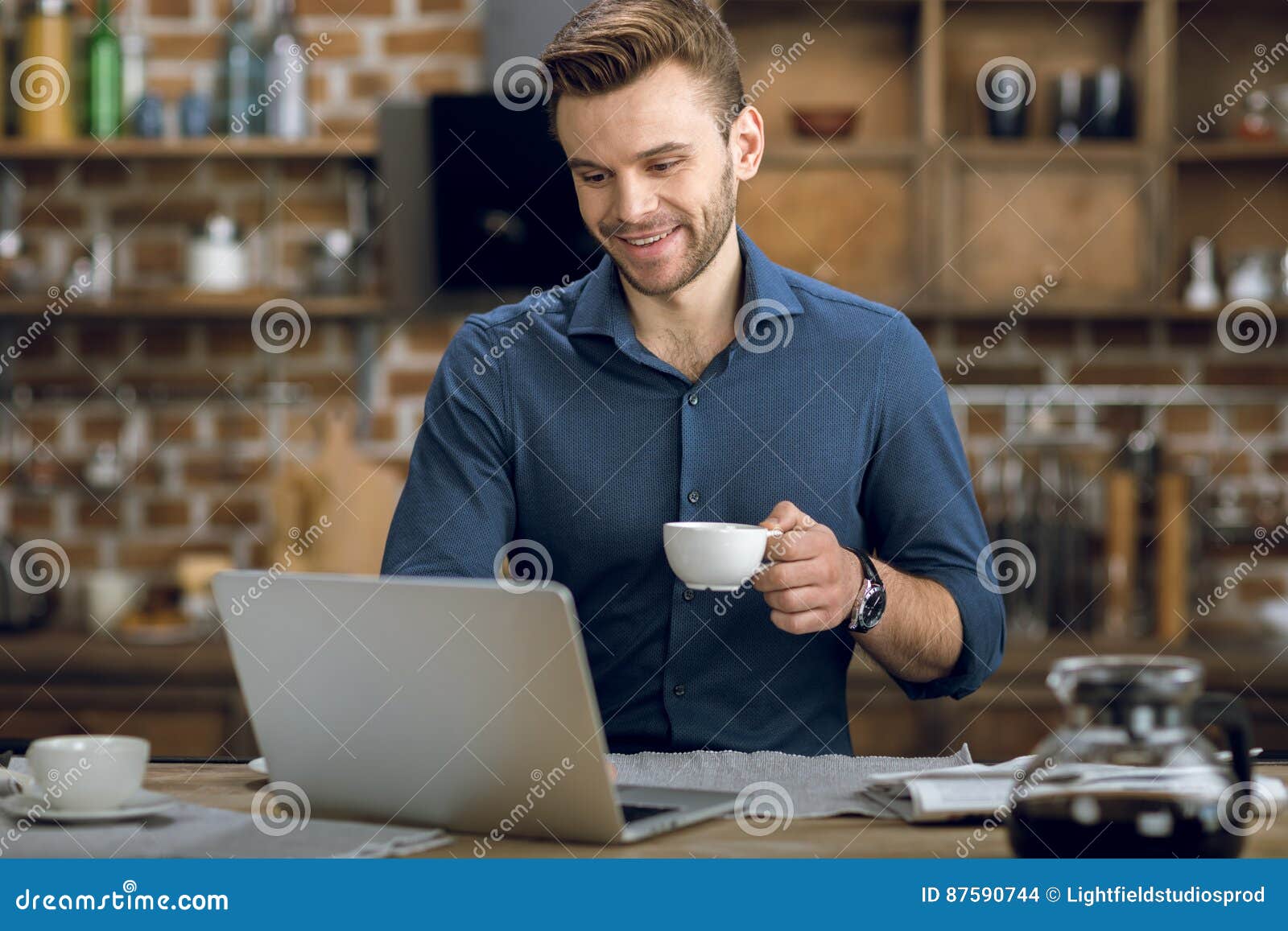 Young Man Using Laptop while Drinking Coffee at Home Stock Photo ...