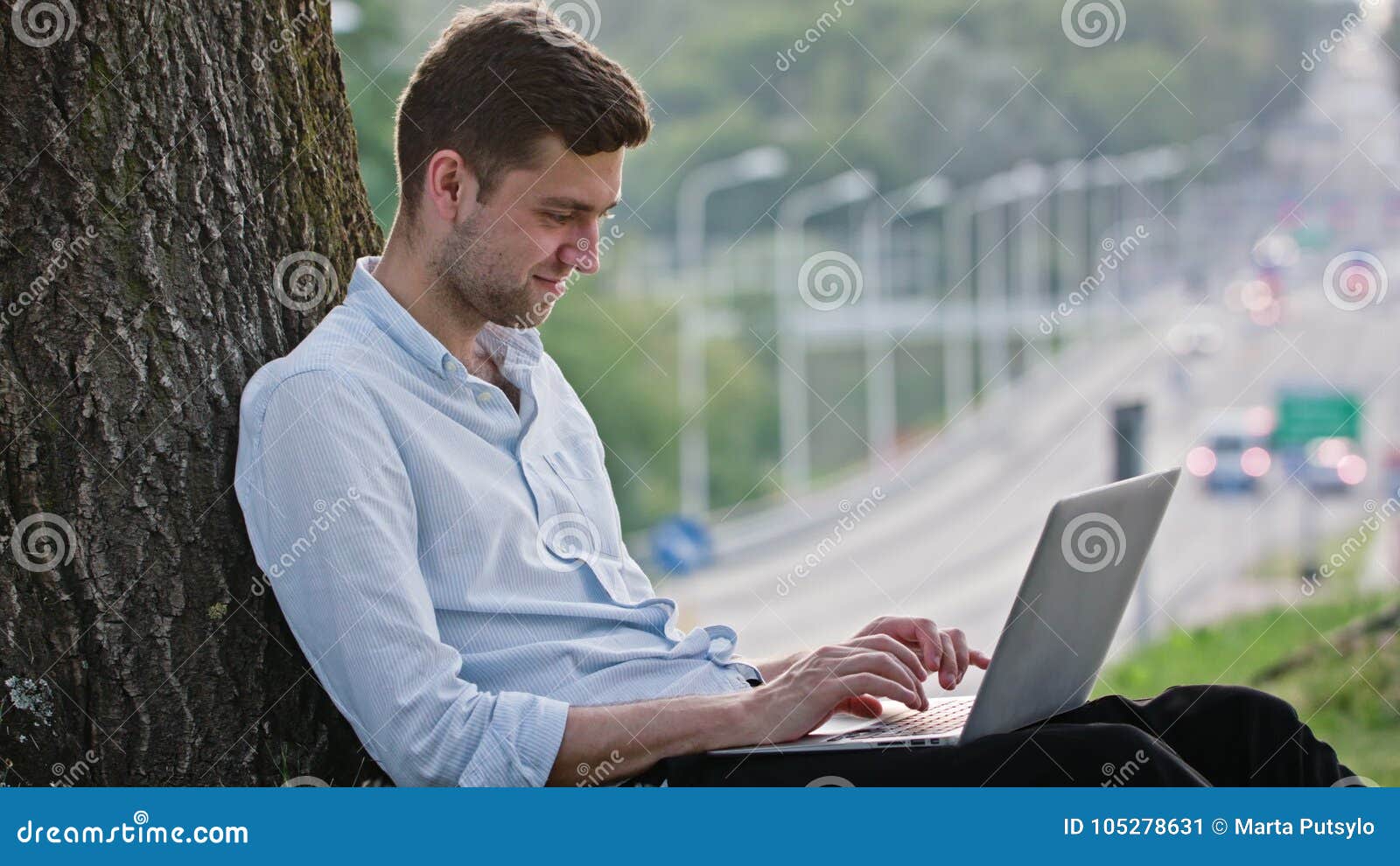 A Young Man Using a Laptop Outdoors Stock Image - Image of cityscape ...
