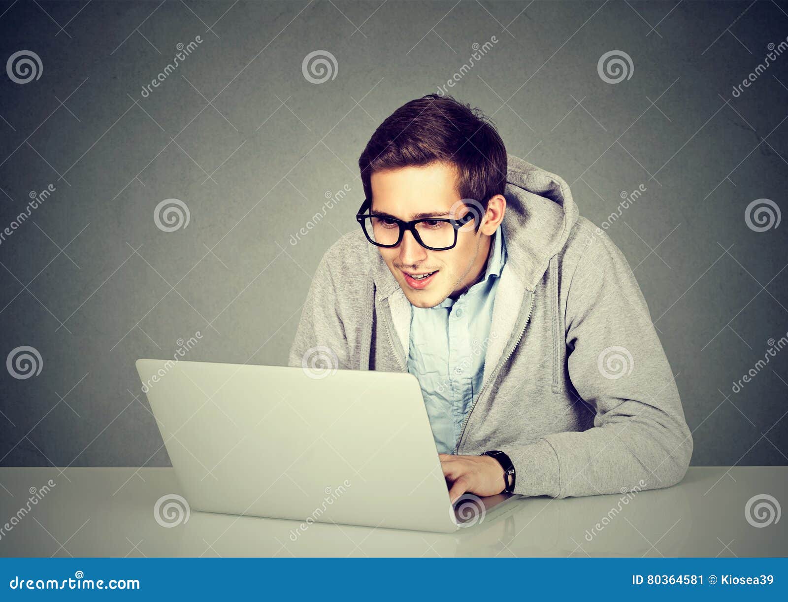 Young Man Using a Laptop Sitting at Table Stock Image - Image of ...