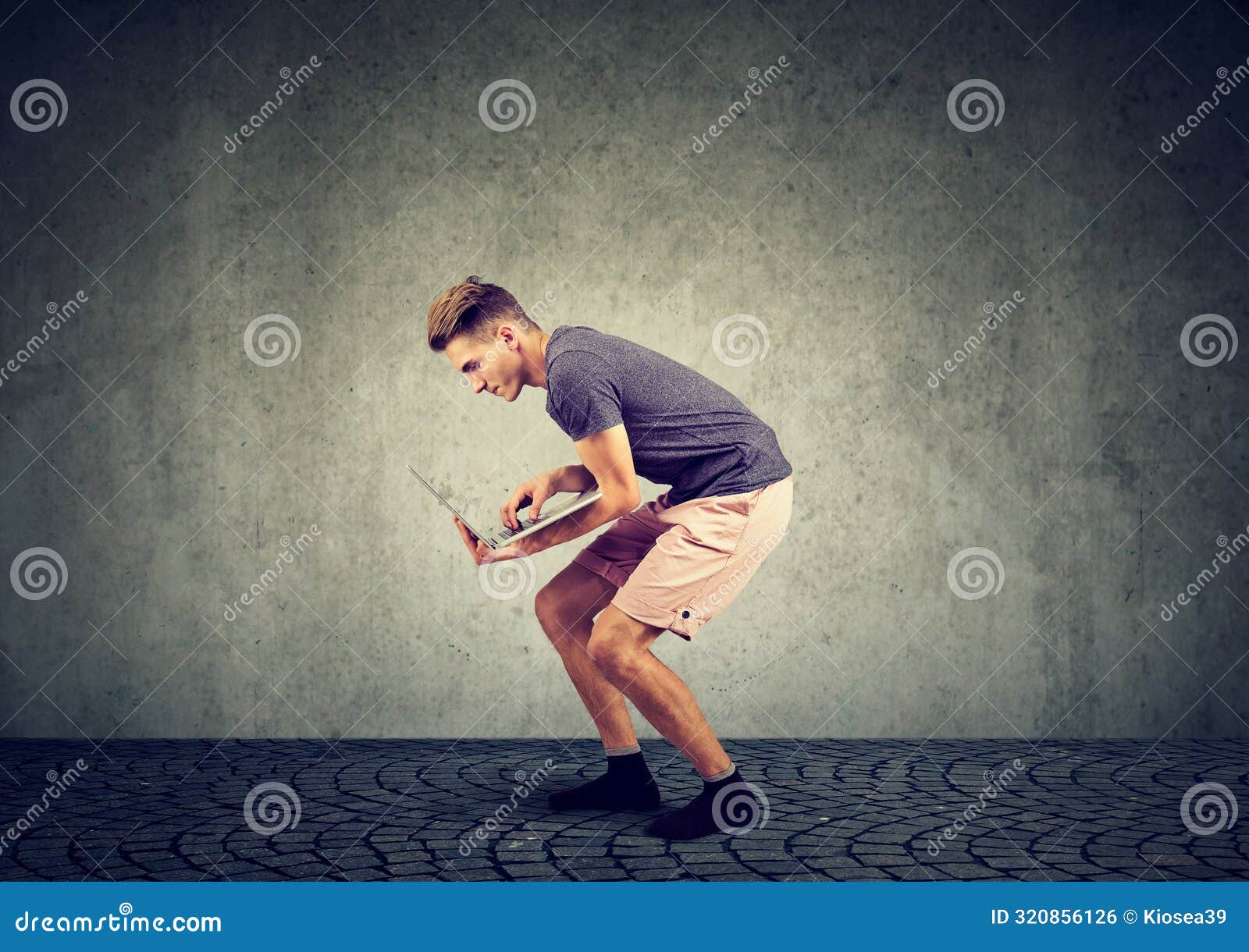 Man Using Laptop while Squatting Along the Wall Stock Photo - Image of ...