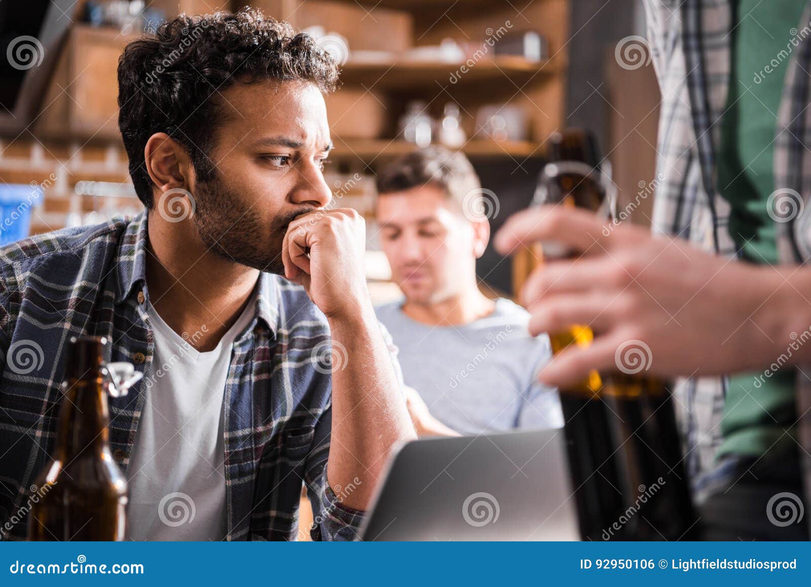 Young Man Using Laptop while Young People Having Fun with Beer Stock ...