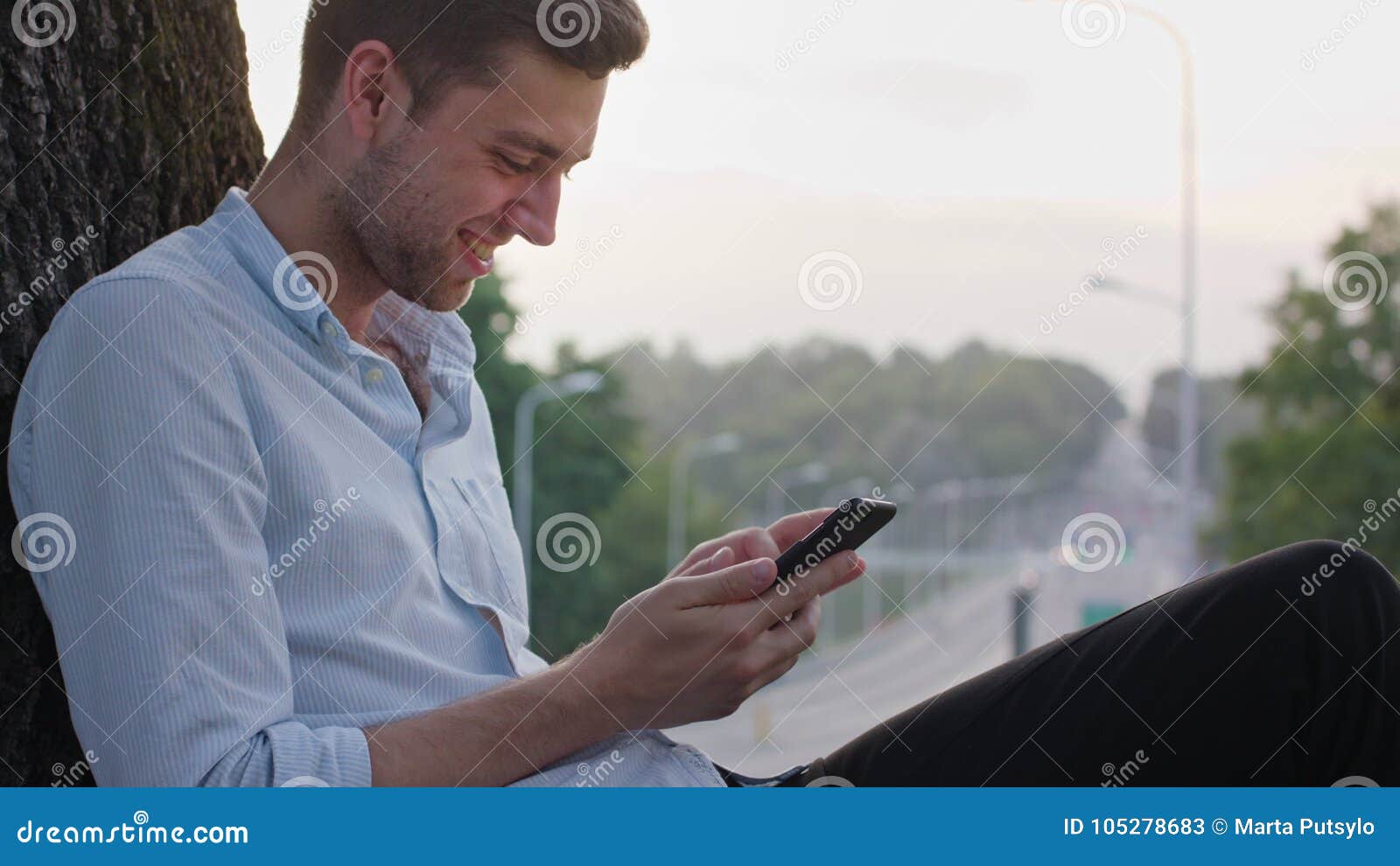 A Young Man Using a Mobile Outdoors Stock Image - Image of people ...