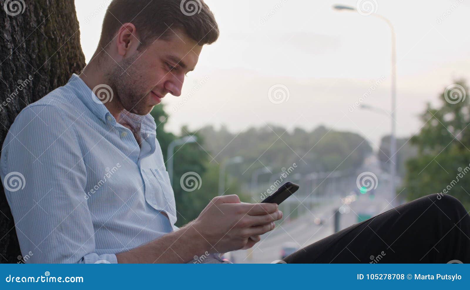 A Young Man Using a Mobile Outdoors Stock Photo - Image of outside ...