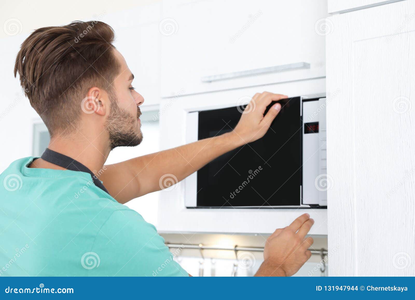 Young Man Using Modern Microwave Oven Stock Photo - Image of device ...