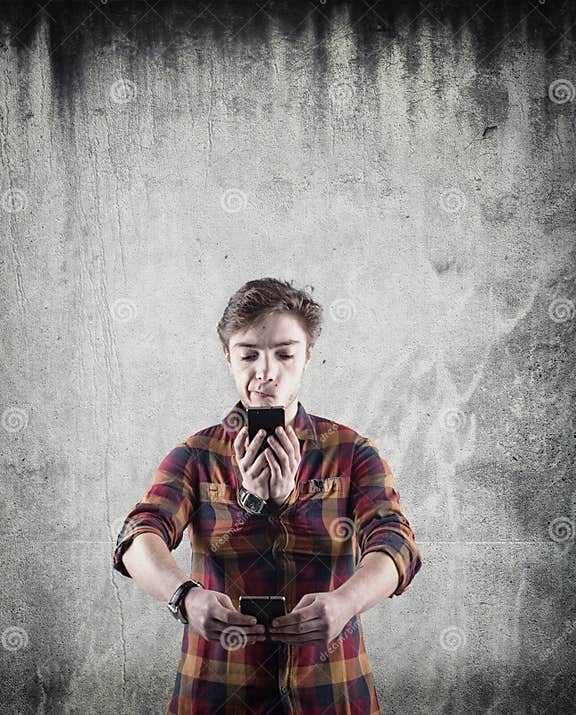 Young Man Using 2 Phones at Once Stock Photo - Image of message ...