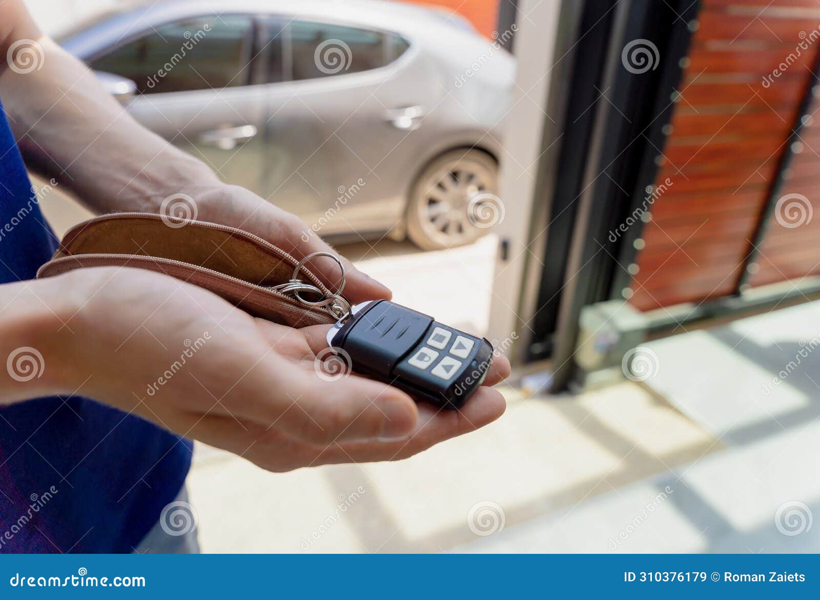 Young Man Using Remote Control To Open Automatic Sliding Front Gate at ...