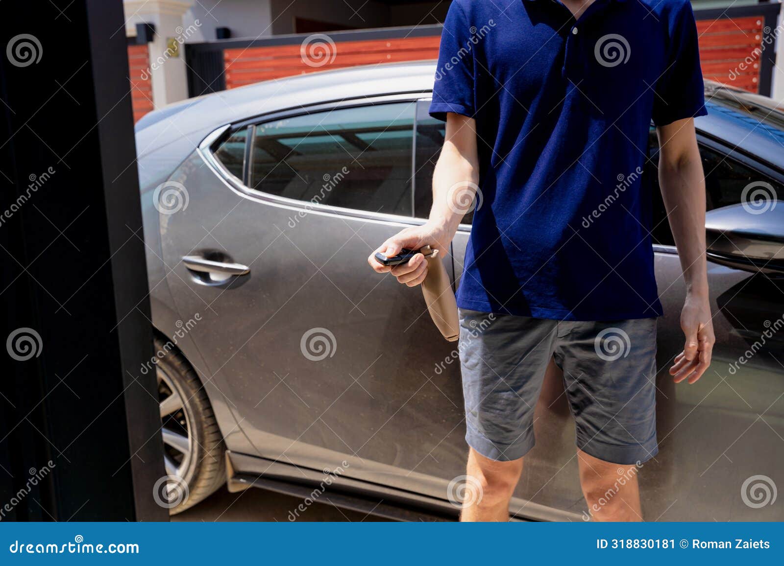 Young Man Using Remote Control To Open Automatic Sliding Front Gate at ...