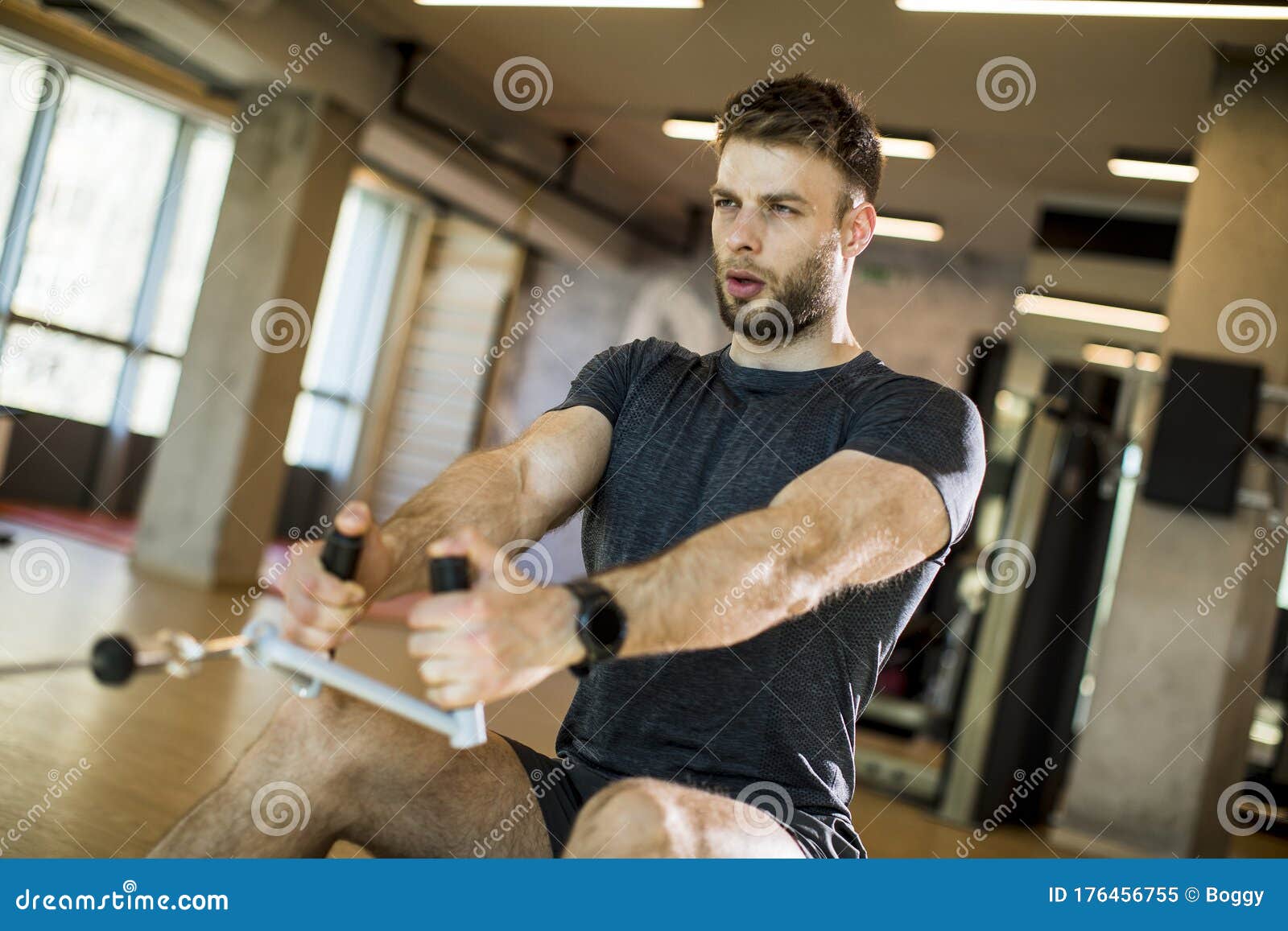 Young Man Using Seated Row Machine in the Gym Stock Image - Image of ...