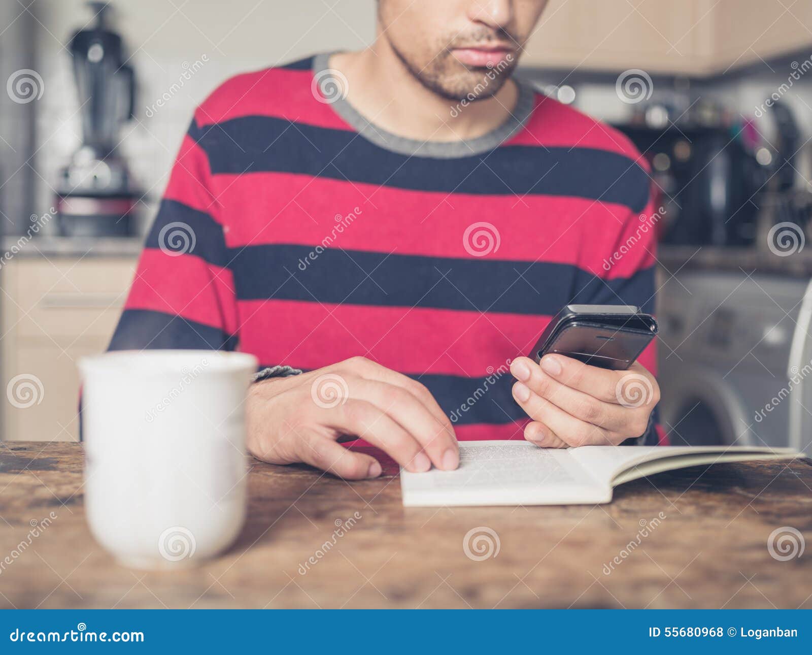 Young Man Using Smart Phone and Reading Stock Photo - Image of book ...