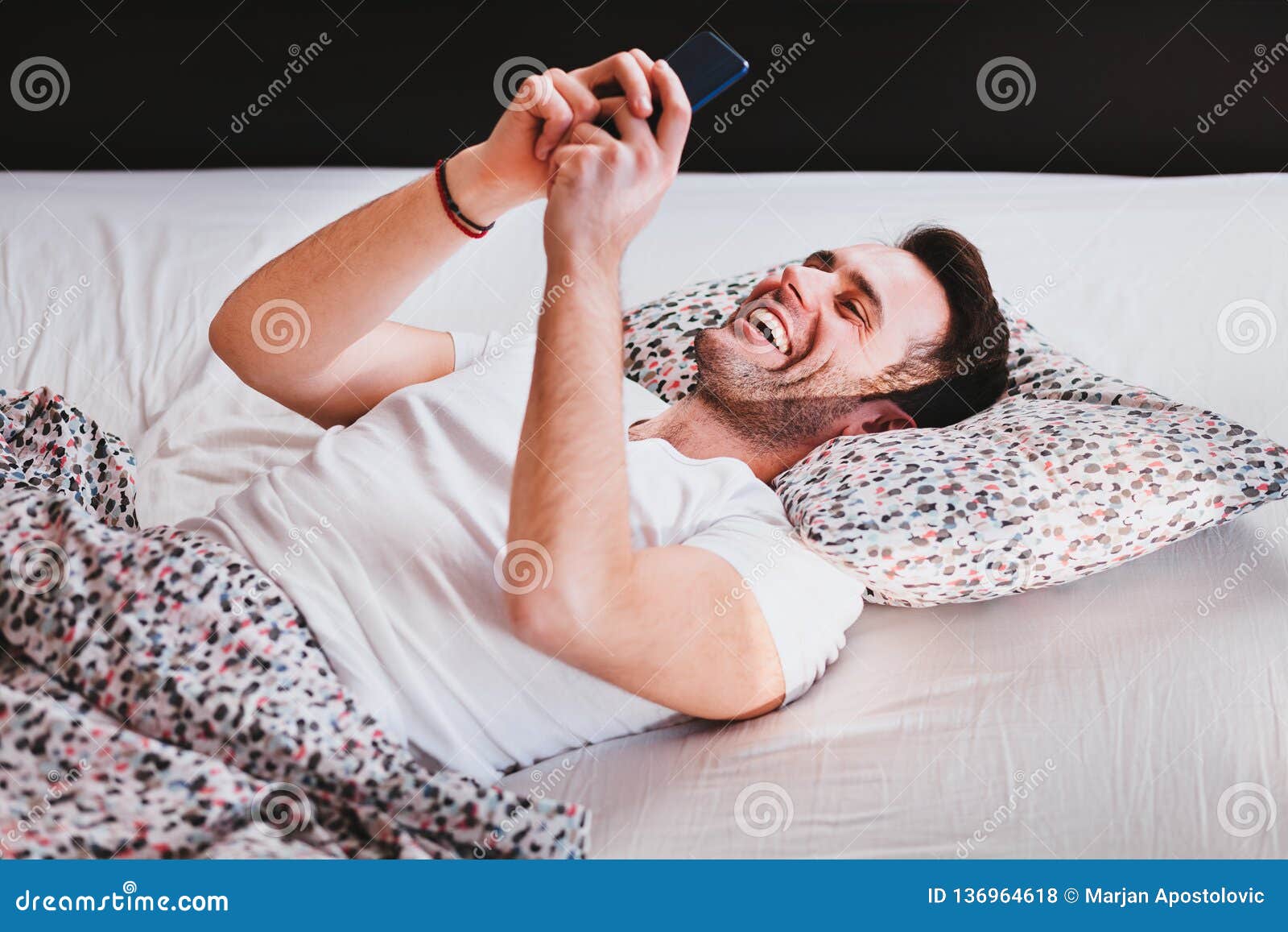 Young Man Using Smartphone in Bed Stock Photo - Image of cell, bedroom ...