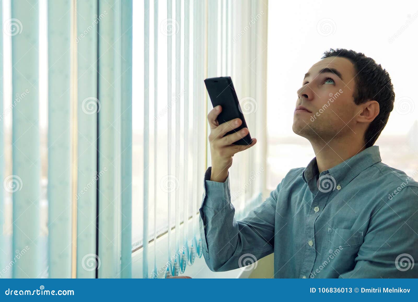 Young Man Using a Smartphone in Front of a Window. Stock Image - Image ...