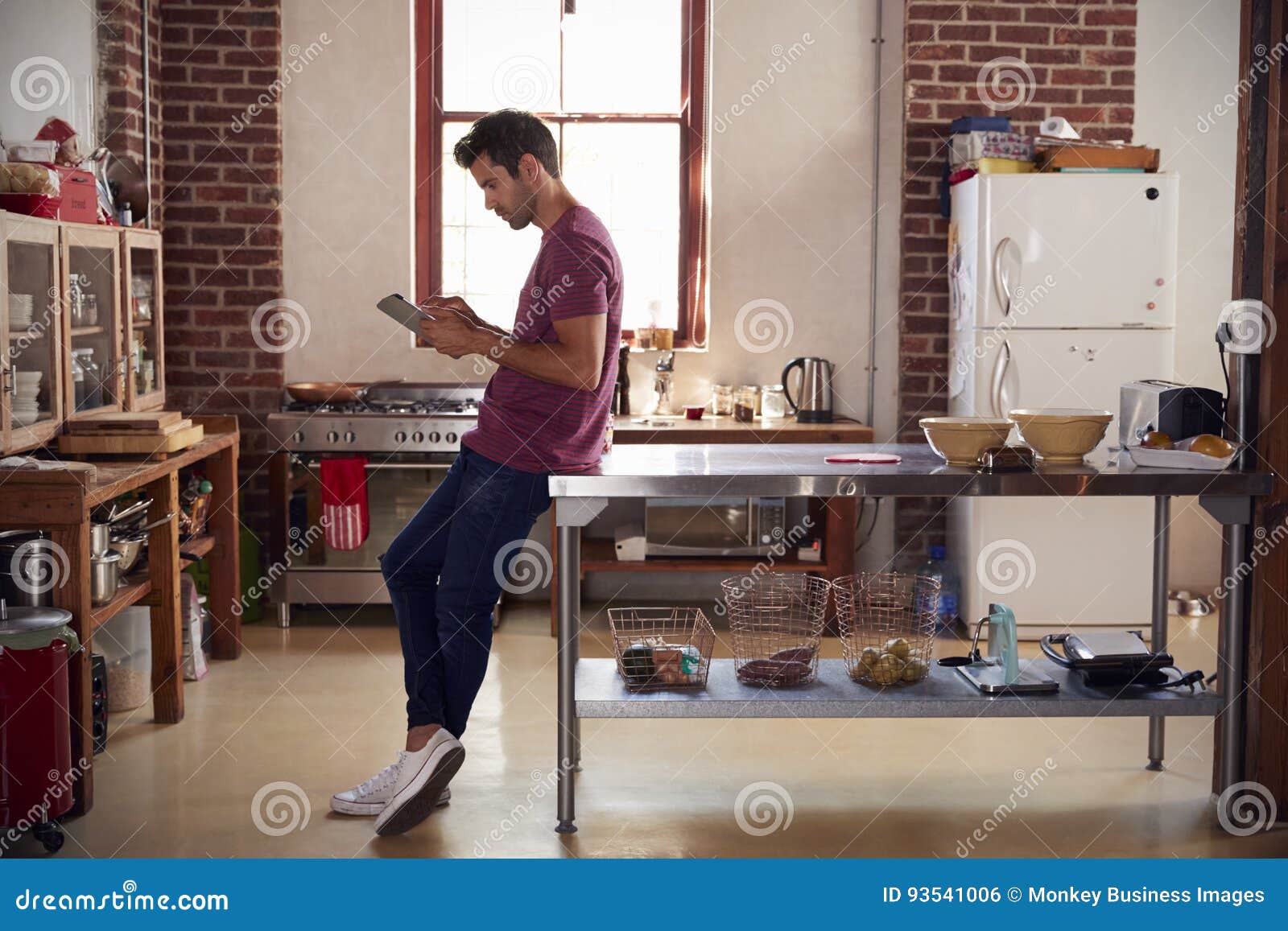 Young Man Using Tablet Computer in Kitchen, Full Length Stock Photo ...