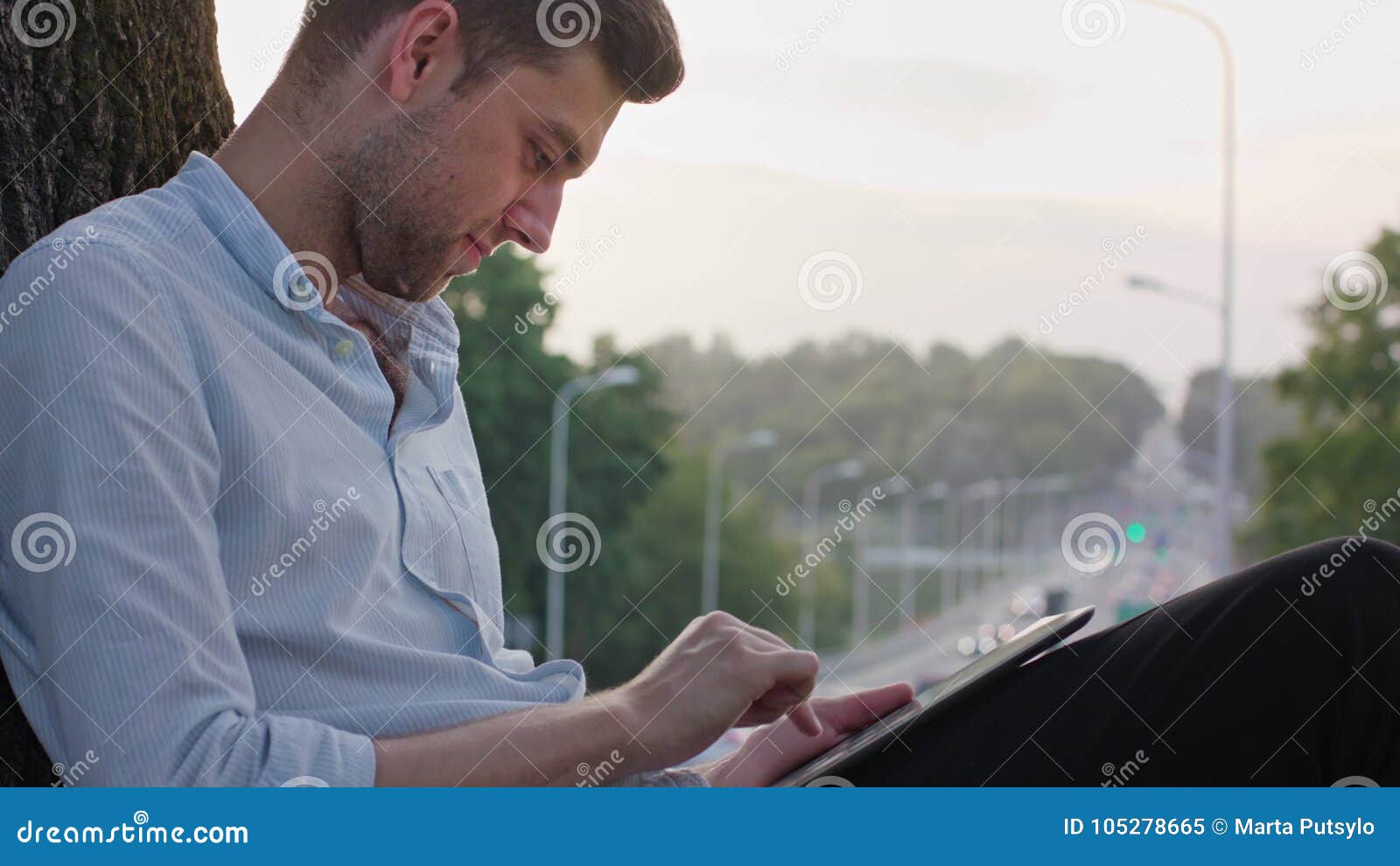 A Young Man Using a Tablet Outdoors Stock Image - Image of music ... A Young Man Using a Tablet Outdoors Stock Image - Image of music ...