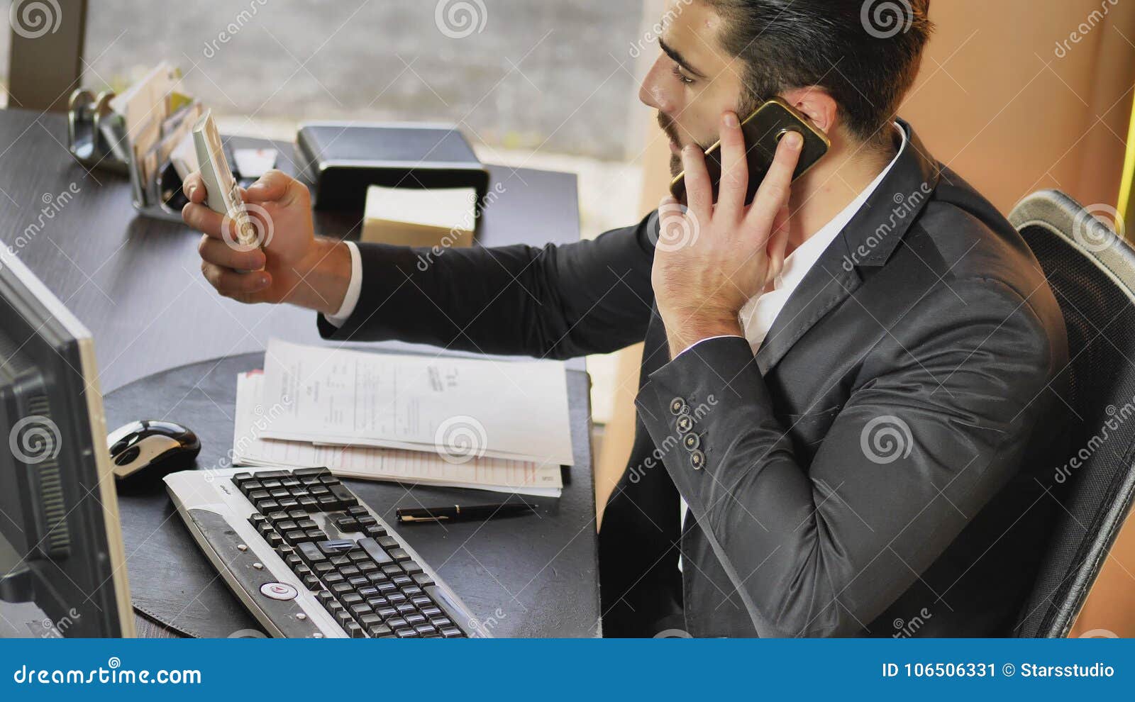 Young Man Using Two Mobile Phones and Computer Stock Image - Image of ...