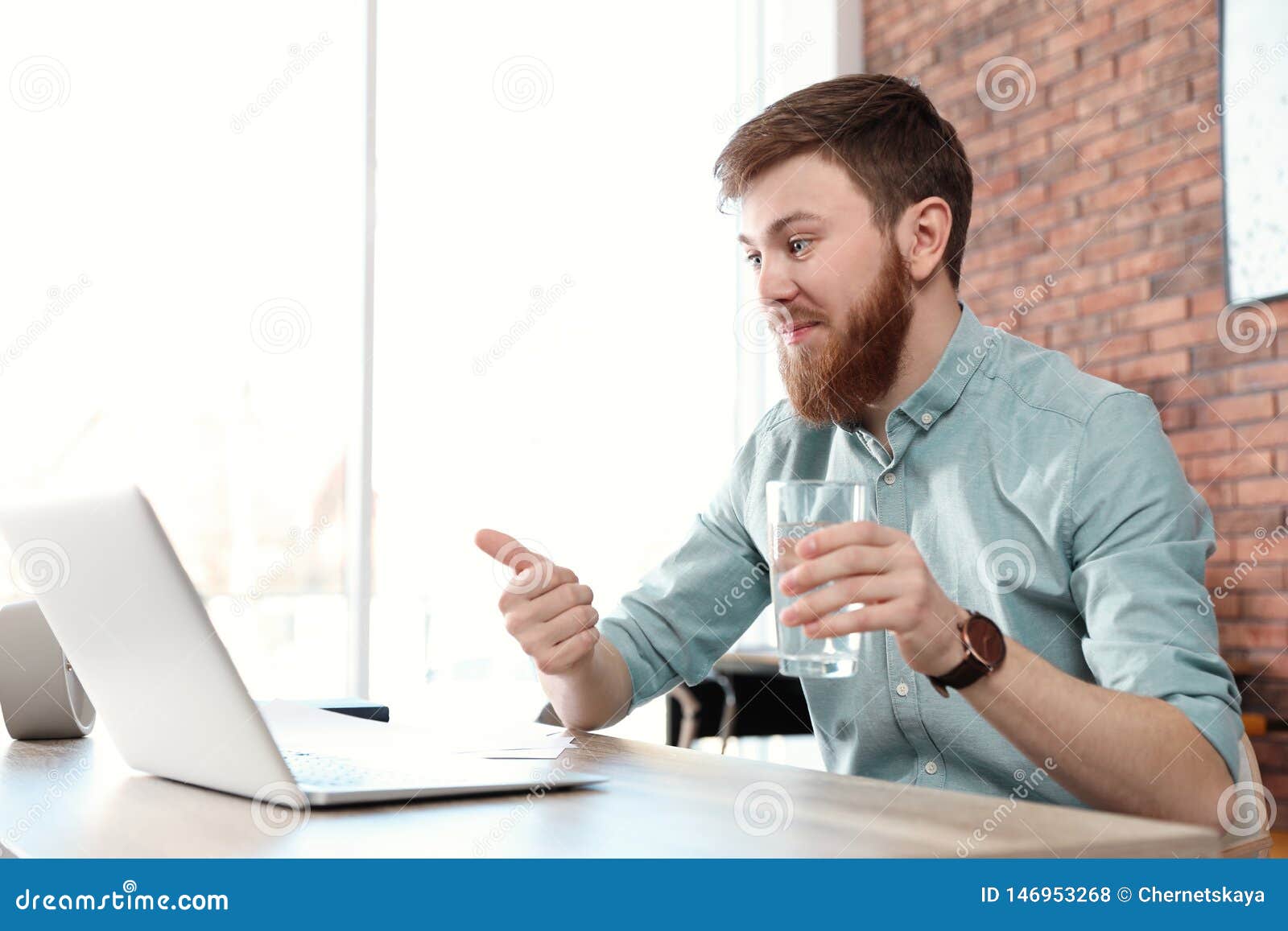 Young Man Using Video Chat on Laptop in Office Stock Photo - Image of ...