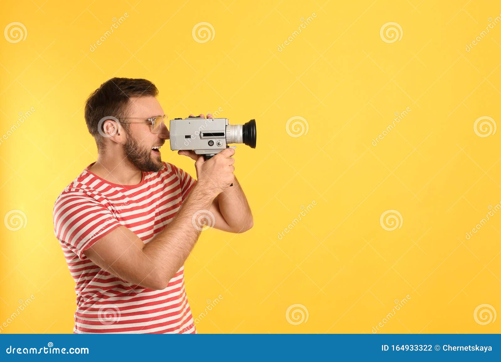 Young Man Using Vintage Video Camera on Background, Space for Text ...