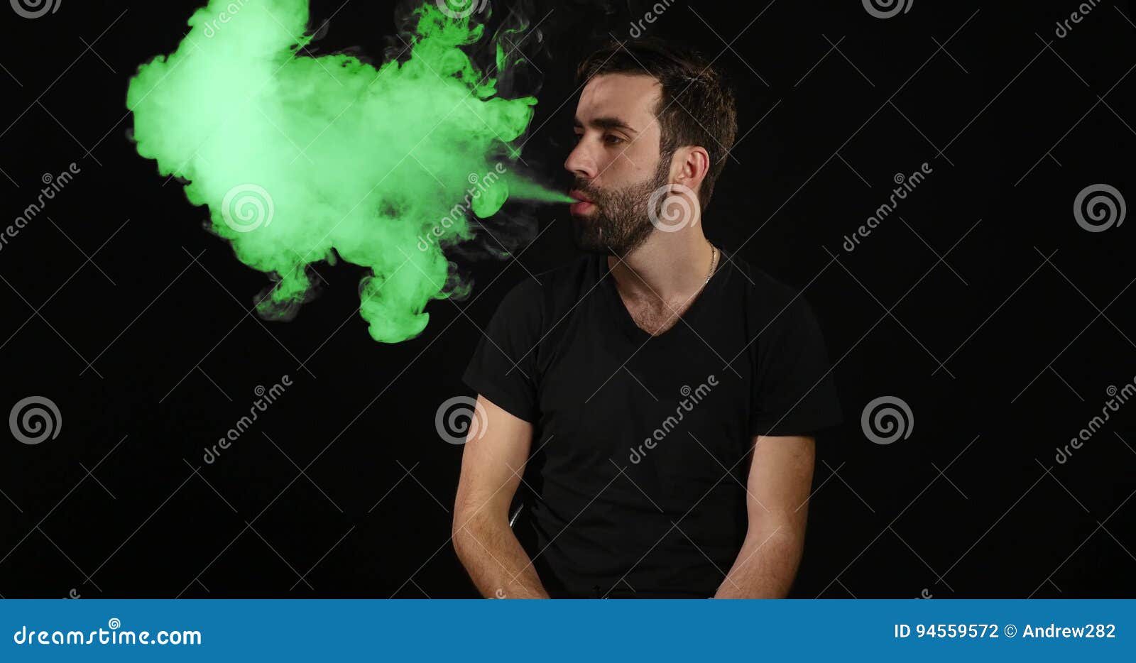 Young Man Vaping with an Electronic Cigarette and Make Some Green Smoke ...