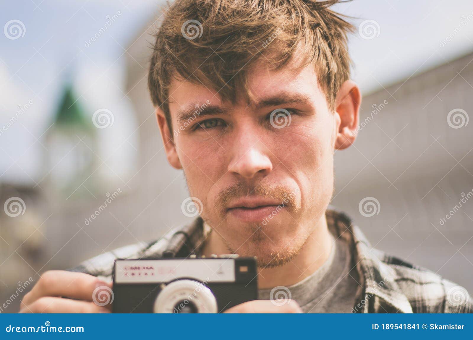 A Young Man with a Vintage Camera in His Hands Looks Seriously Stock ...