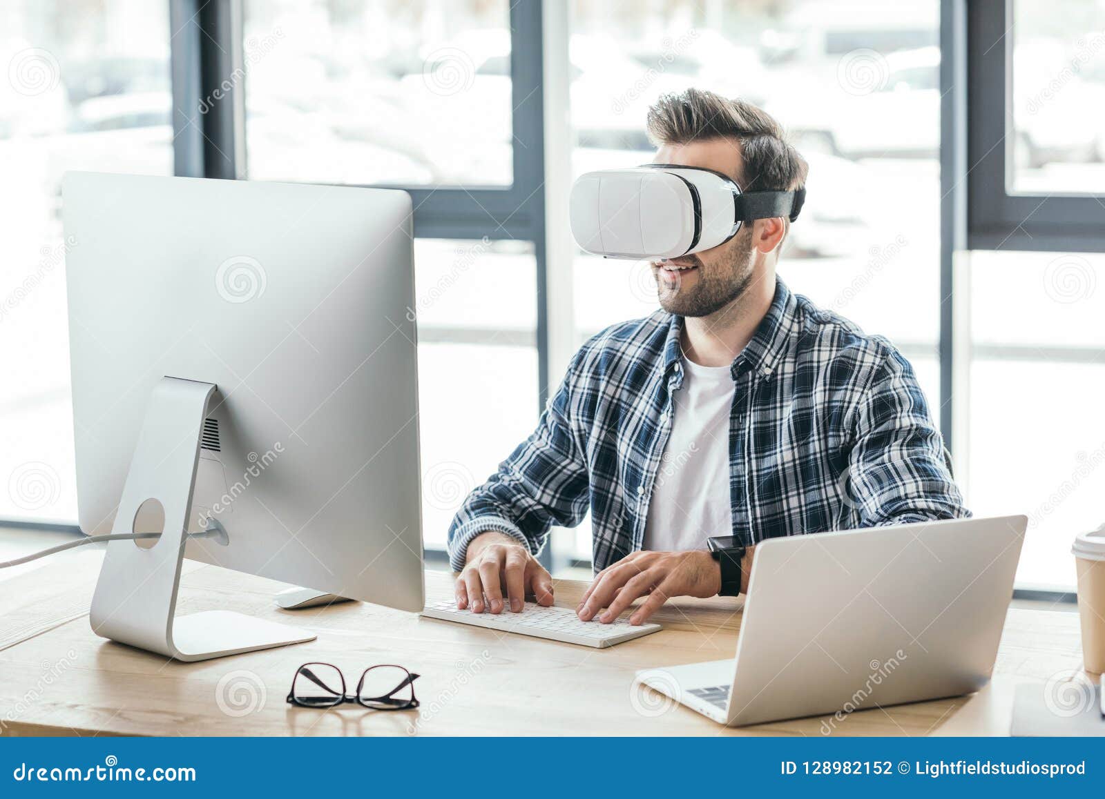 Young Man in Virtual Reality Headset Using Desktop Computer and Laptop ...