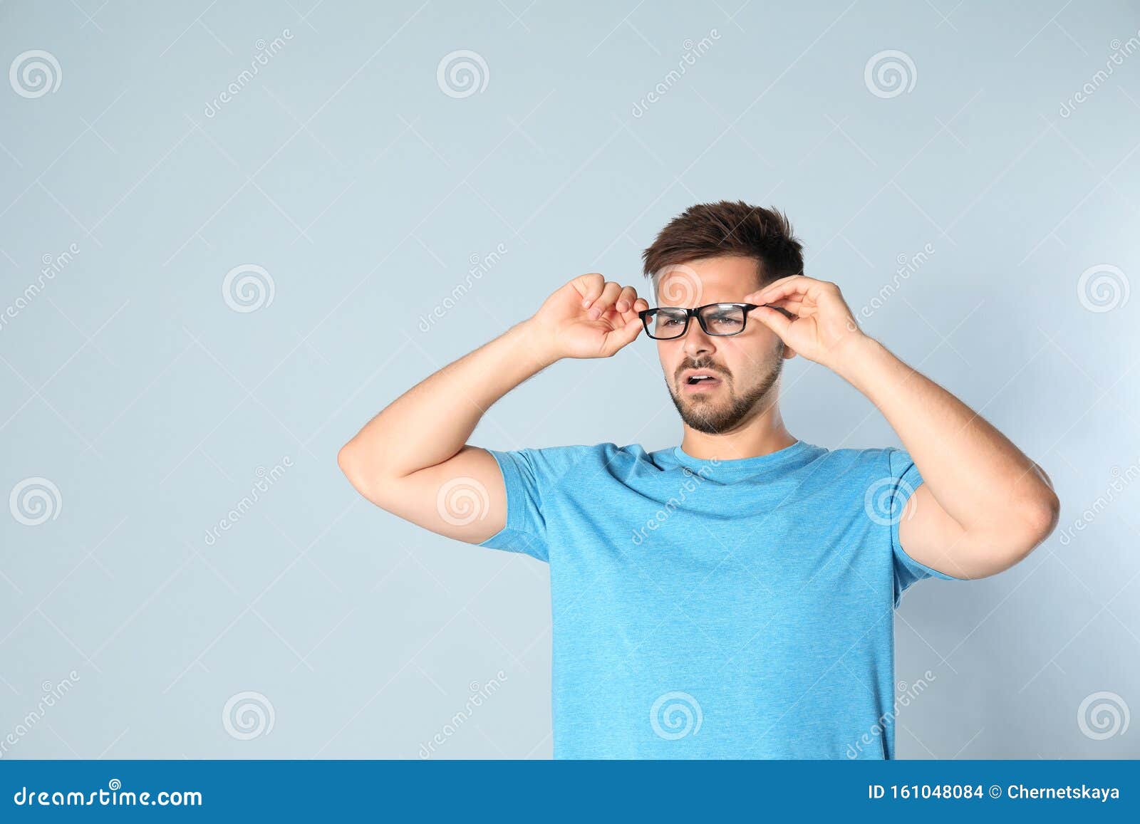 Young Man with Vision Problems Wearing Glasses on Background, Space for ...