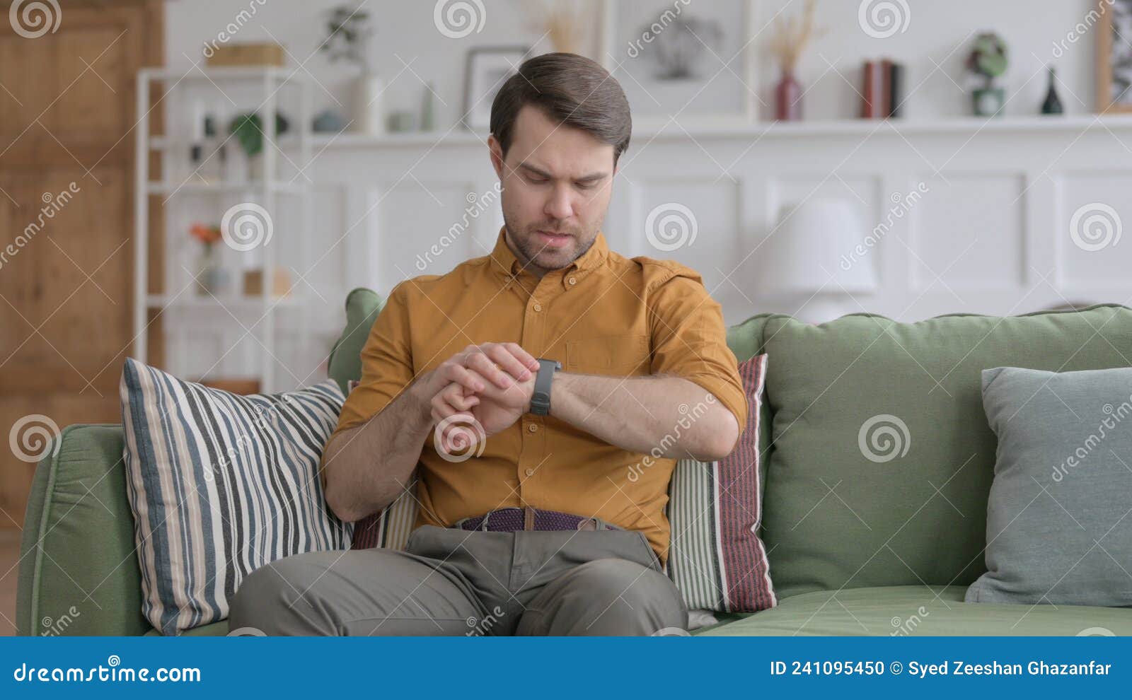 Young Man Waiting while Checking Watch on Sofa Stock Photo - Image of ...