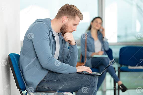 Young Man in Waiting Room Using Computer Stock Photo - Image of time ...