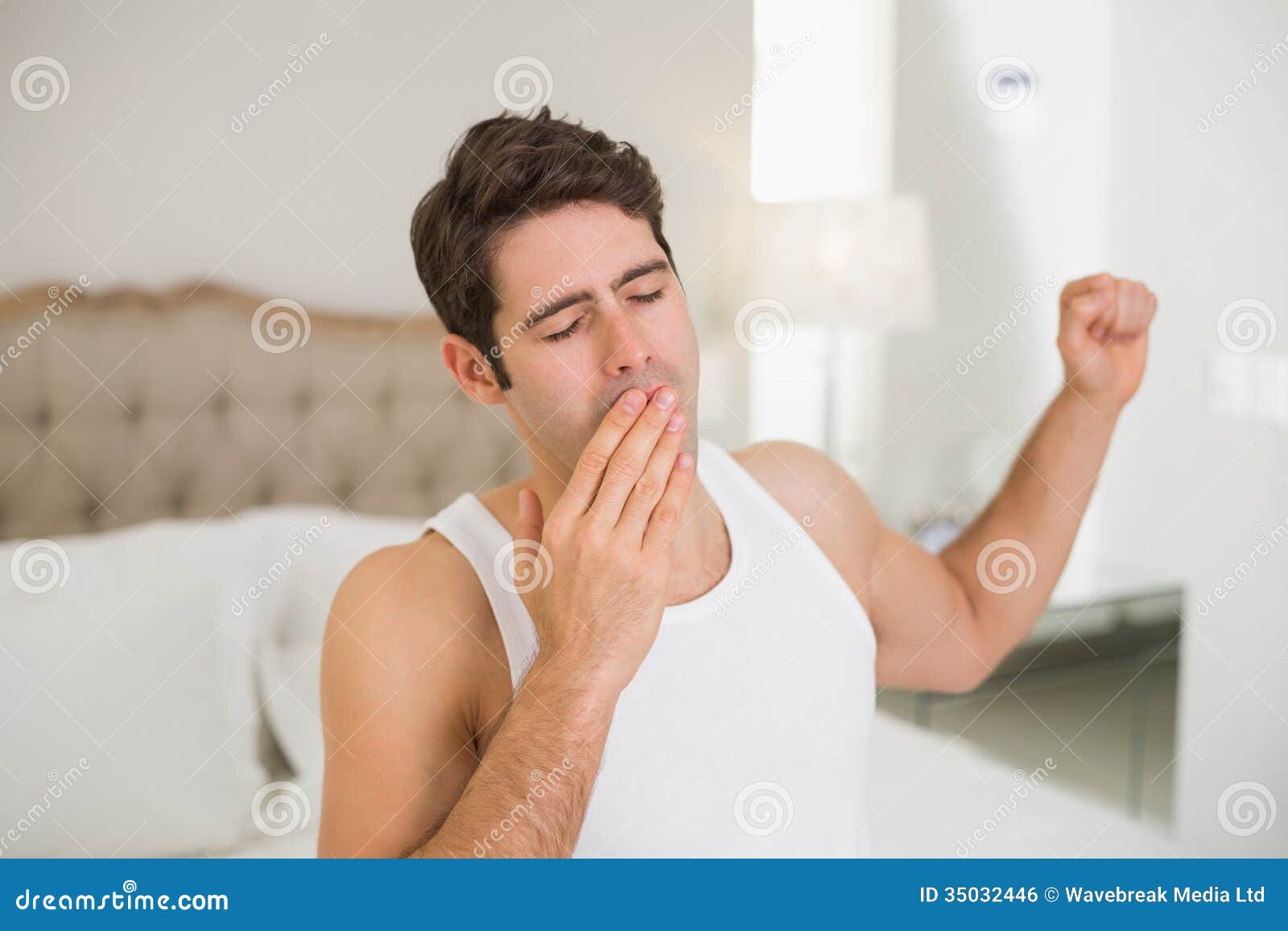 Young Man Waking Up in Bed and Stretching Arms Stock Photo - Image of ...