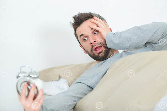 Young man waking up late stock photo. Image of resting - 296715280