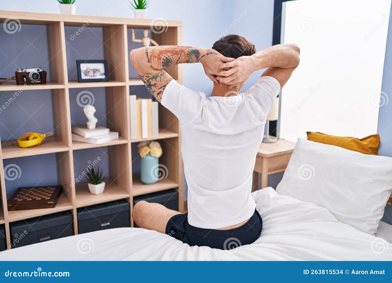 Young Man Waking Up Stretching Arms on Back View at Bedroom Stock Photo ...