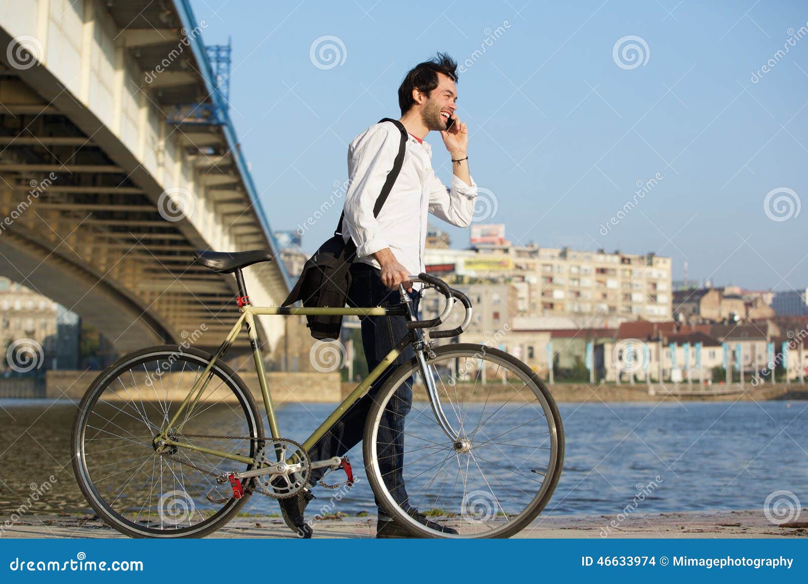Young Man Walking with Bicycle and Talking on Cellphone Stock Photo ...