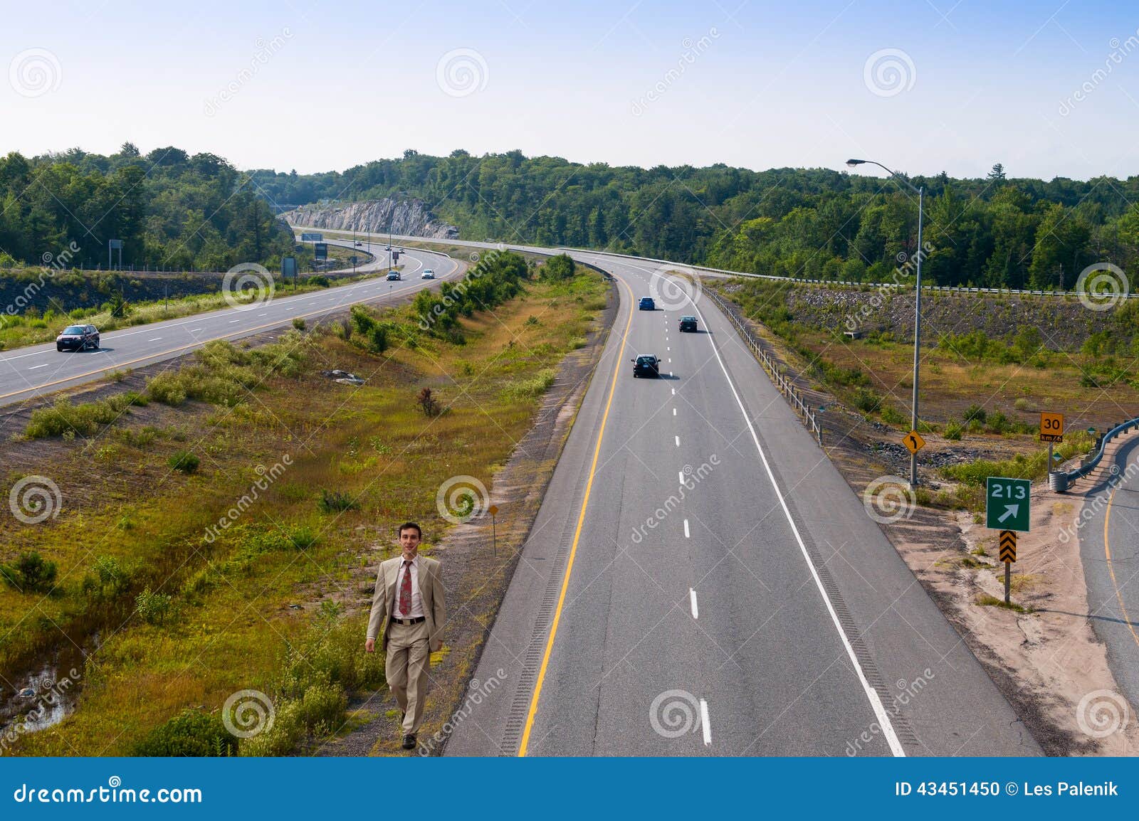 Young Man Walking beside a Highway Stock Photo - Image of busy ...