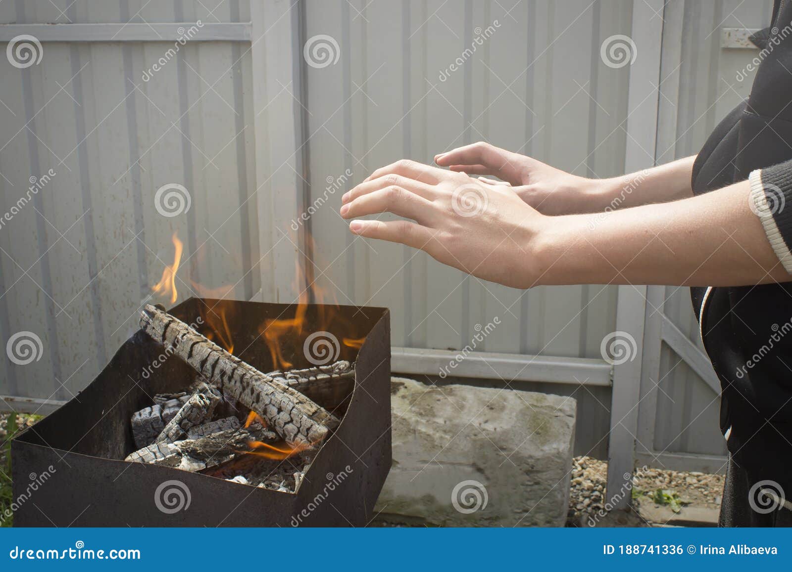 Young Man Warms His Hands Over the Fire. Side View Stock Photo - Image ...