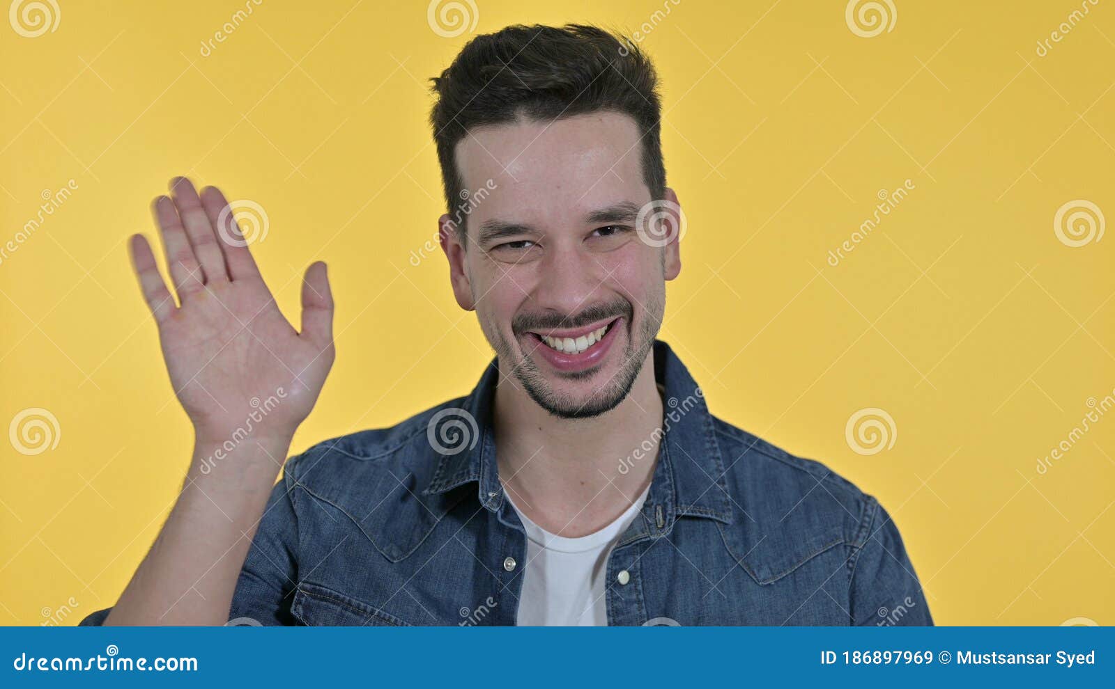 Young Man Waving at the Camera, Yellow Background Stock Image - Image ...
